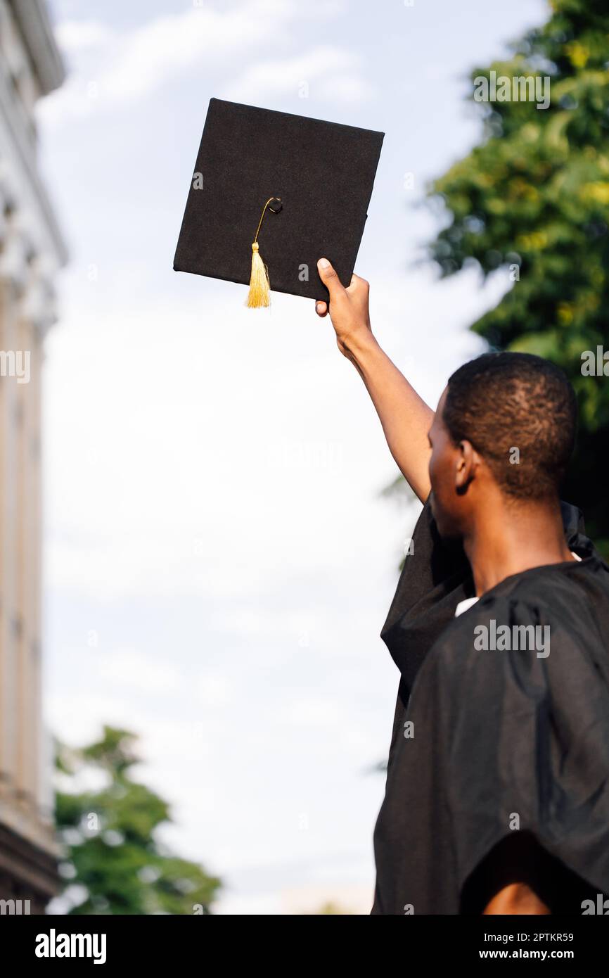 Photo back view of african american graduate from university standing ...