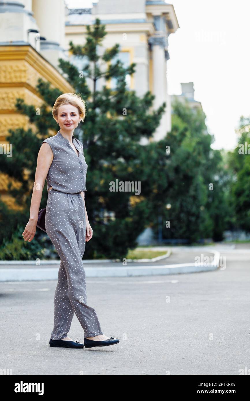 Portrait full length of glamorous 40 years old woman standing half turn ...