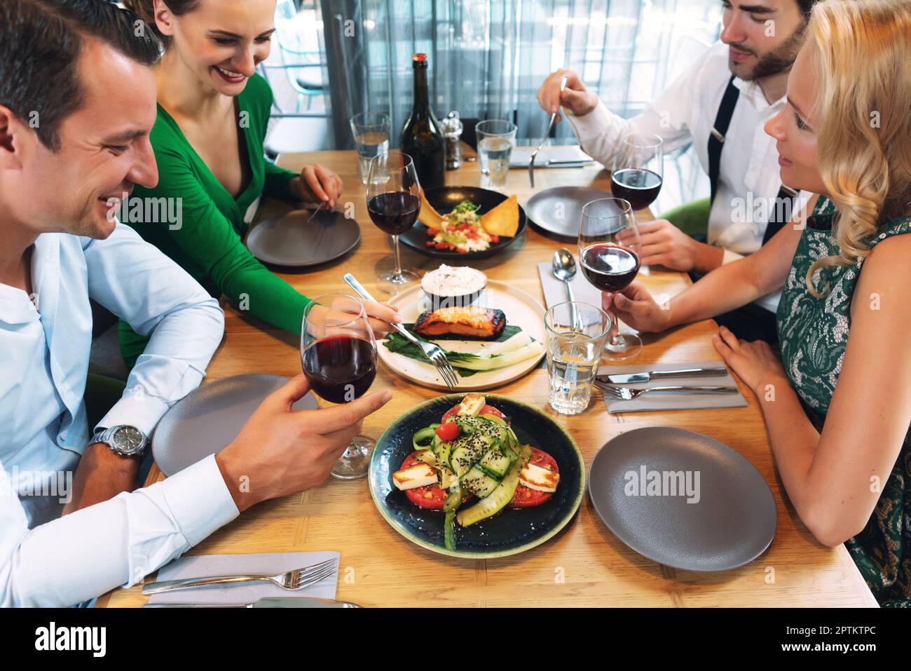 Four Friends enjoying a tasty dinner in a fancy restaurant Stock Photo ...