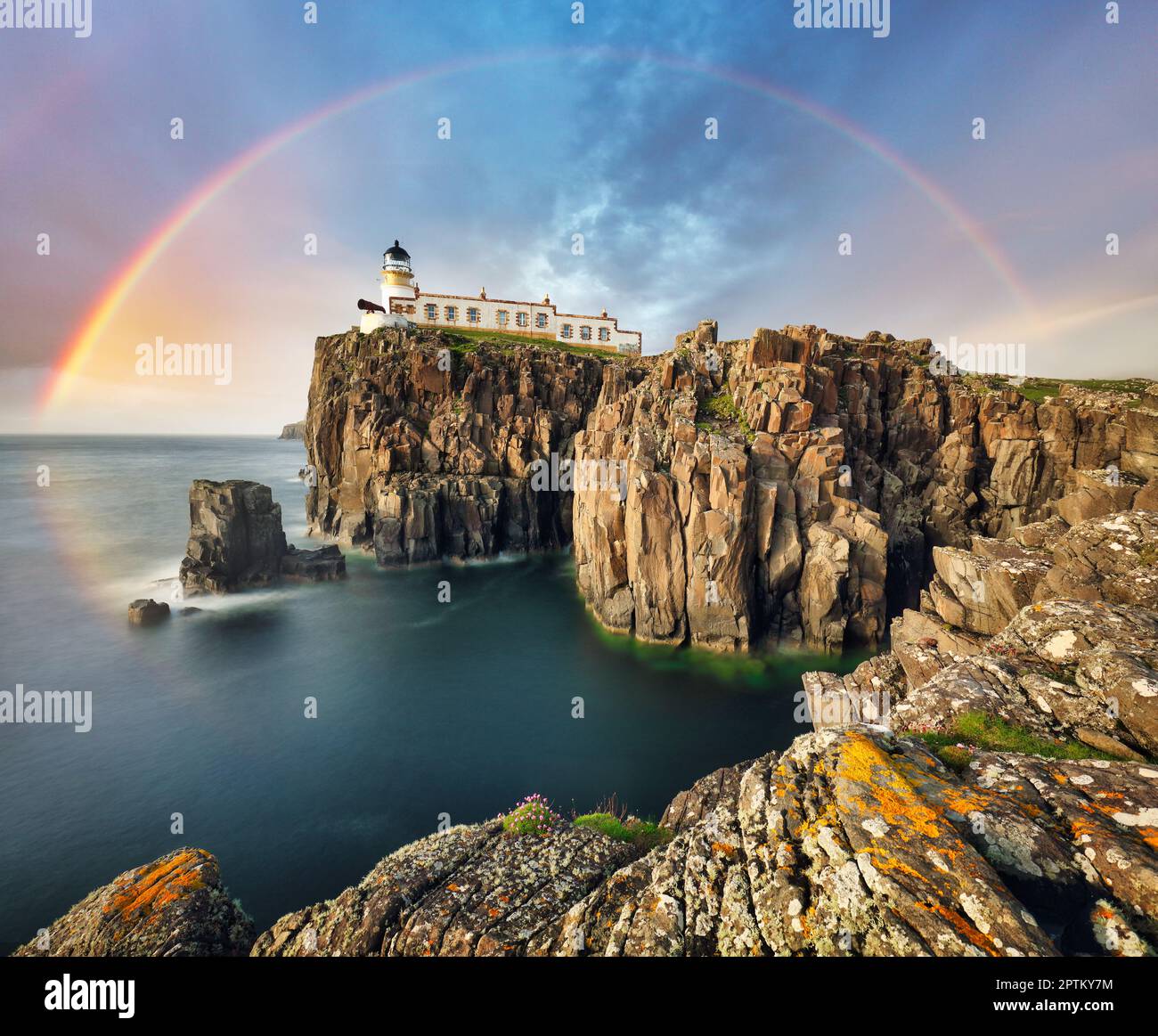 Rainbow over Neist Point Lighthouse on the green cliffs of the Isle of ...