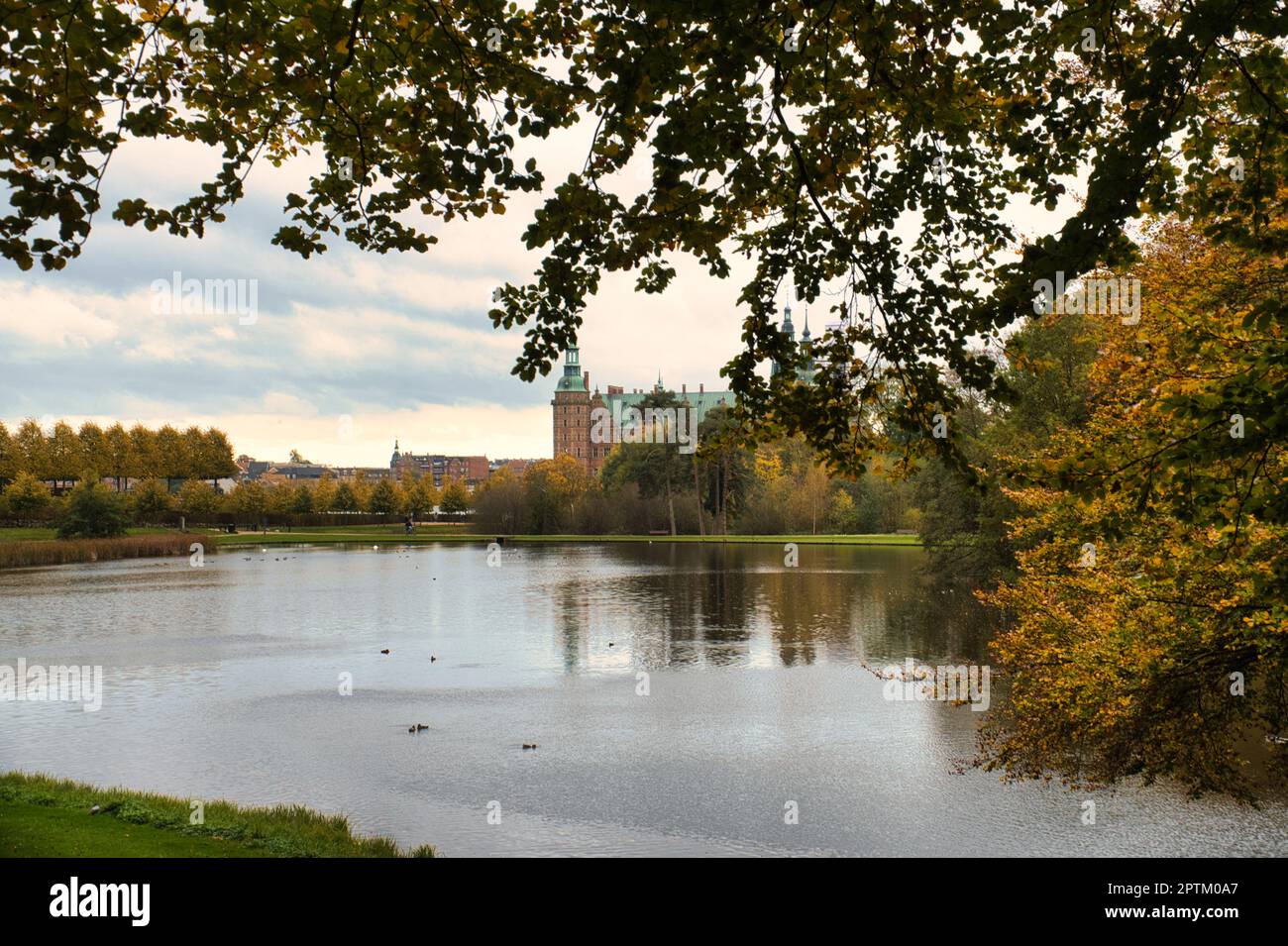 Frederiksborg Castle Park in autumn with mighty deciduous trees on the garden meadows and ...