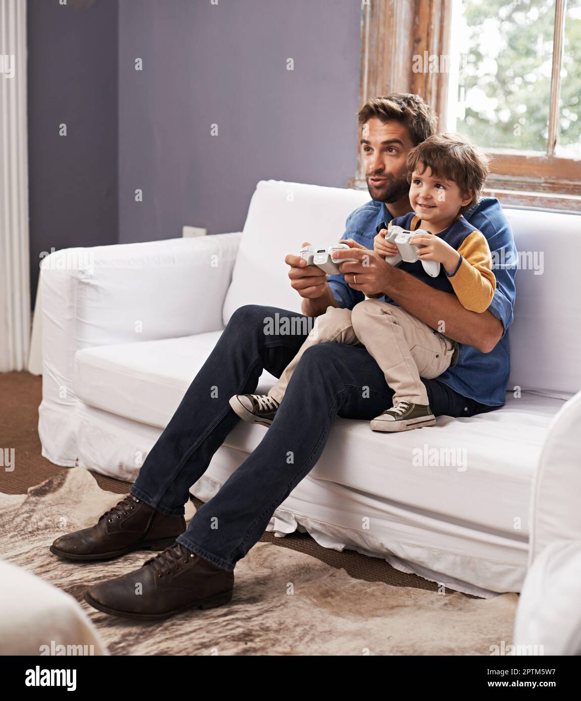 Guys and their games. A handsome father and his cute son playing a ...