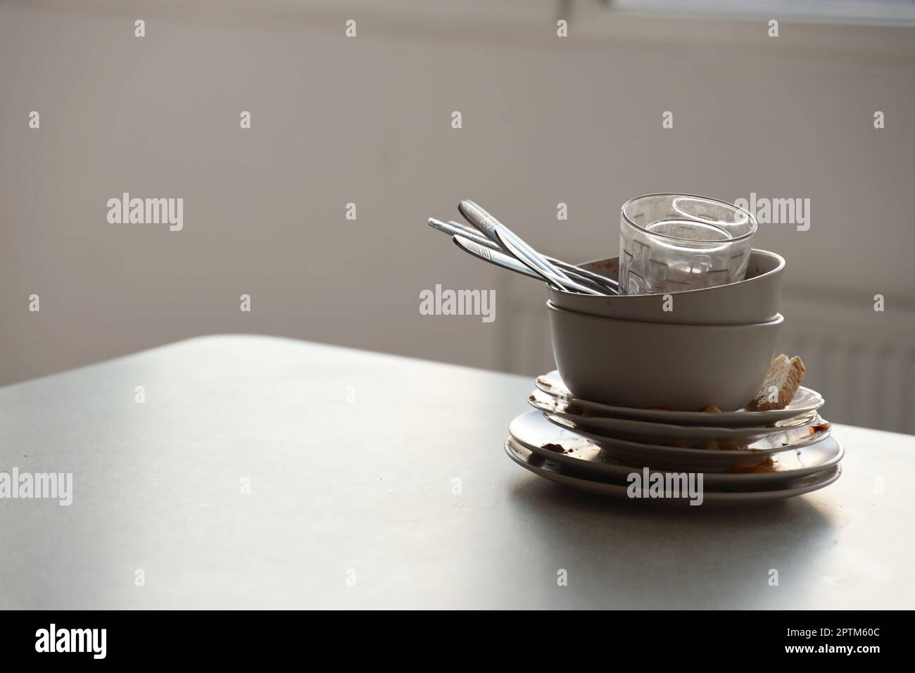 Stack of dirty dishes with food leftovers on the table after meal ...