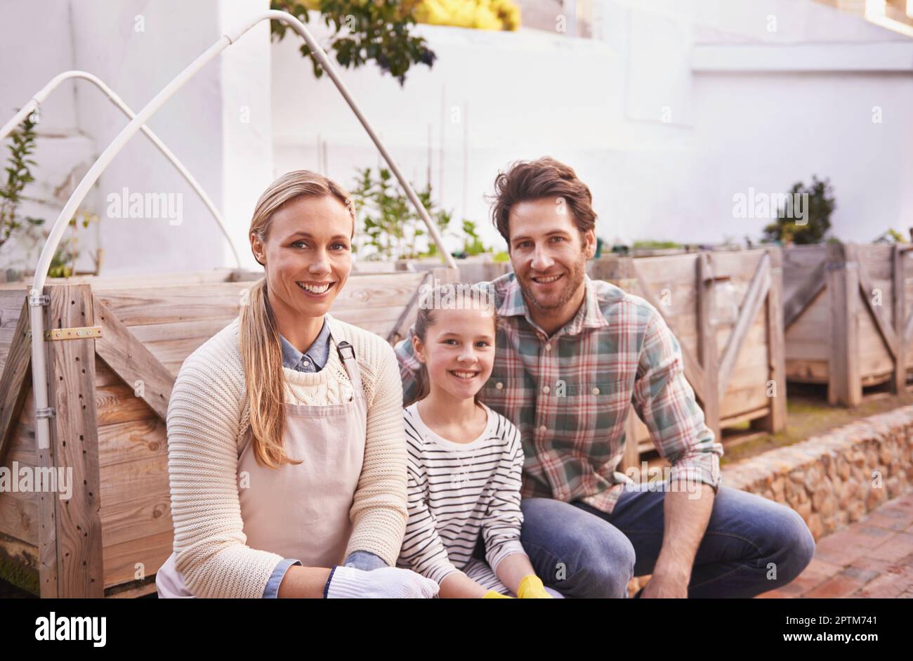 A family that gardens together...Portrait of a happy family taking a ...