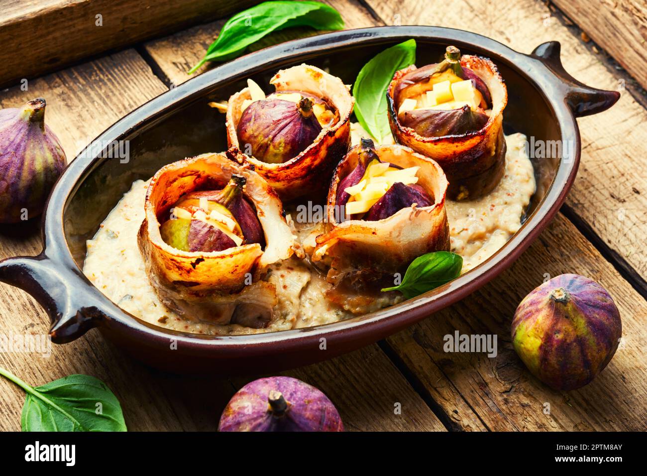 Baked figs with cheese and bacon. Festive autumn snack Stock Photo - Alamy