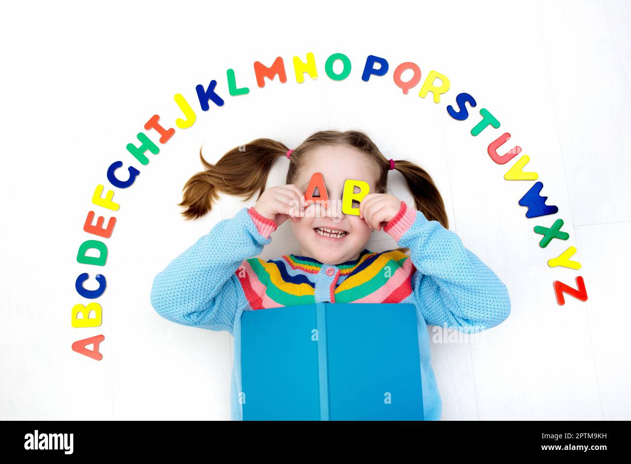 Happy preschool child learning to read and write playing with colorful ...