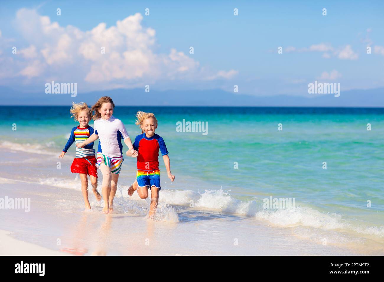 Kids playing on tropical beach. Children swim and play at sea on summer ...