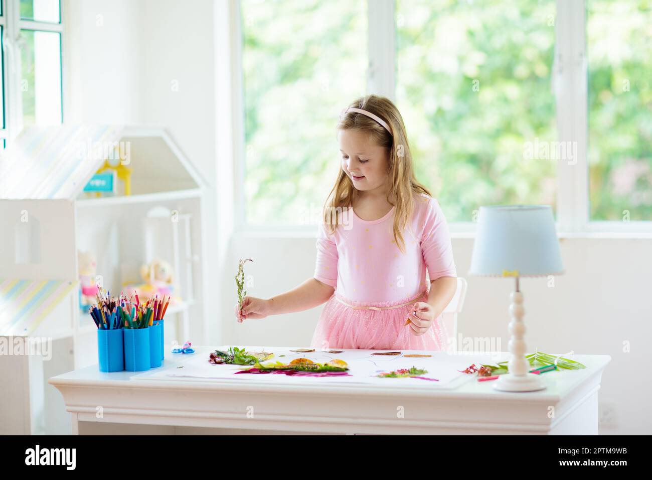 Child creating picture with colorful leaves. Art and crafts for kids ...
