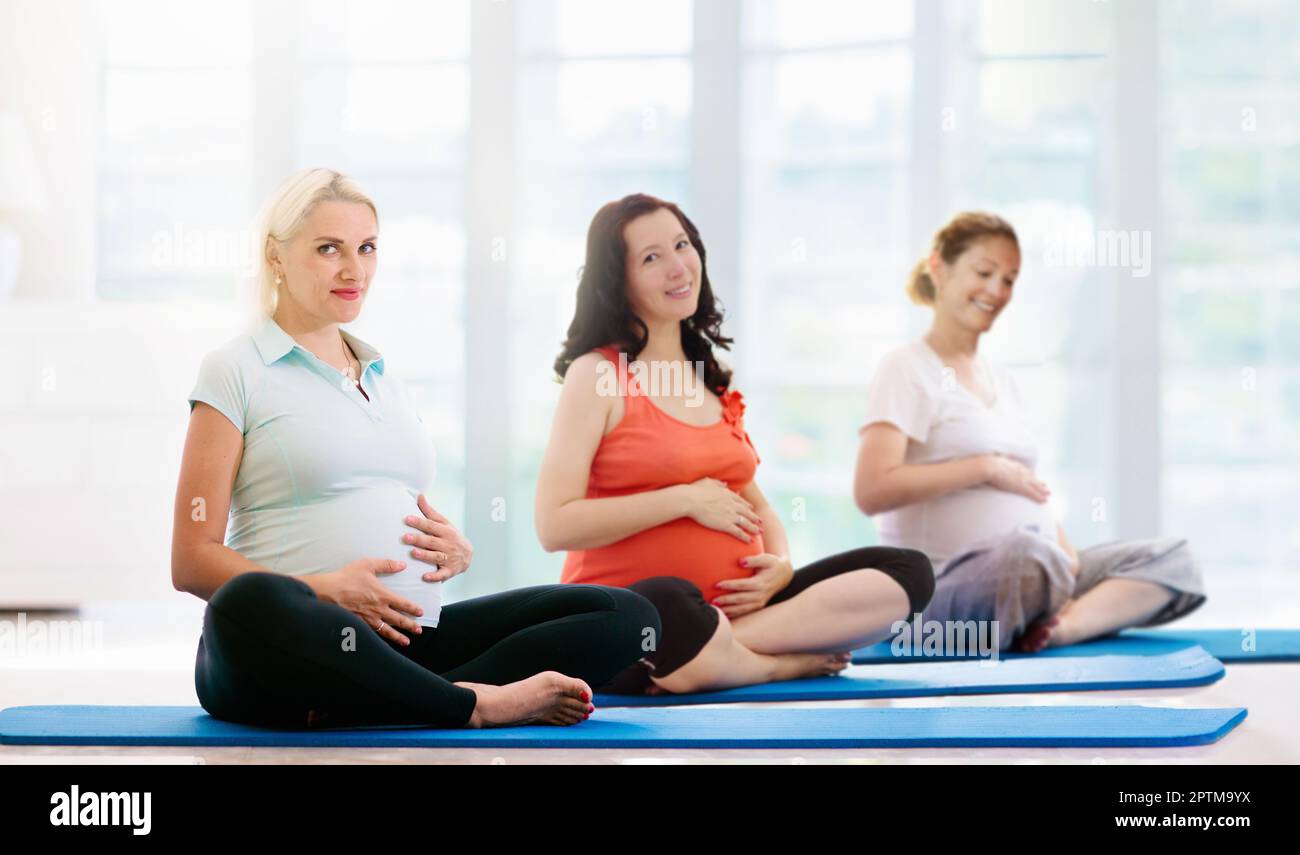 Pregnancy yoga class. Group exercise for pregnant woman. Active female ...