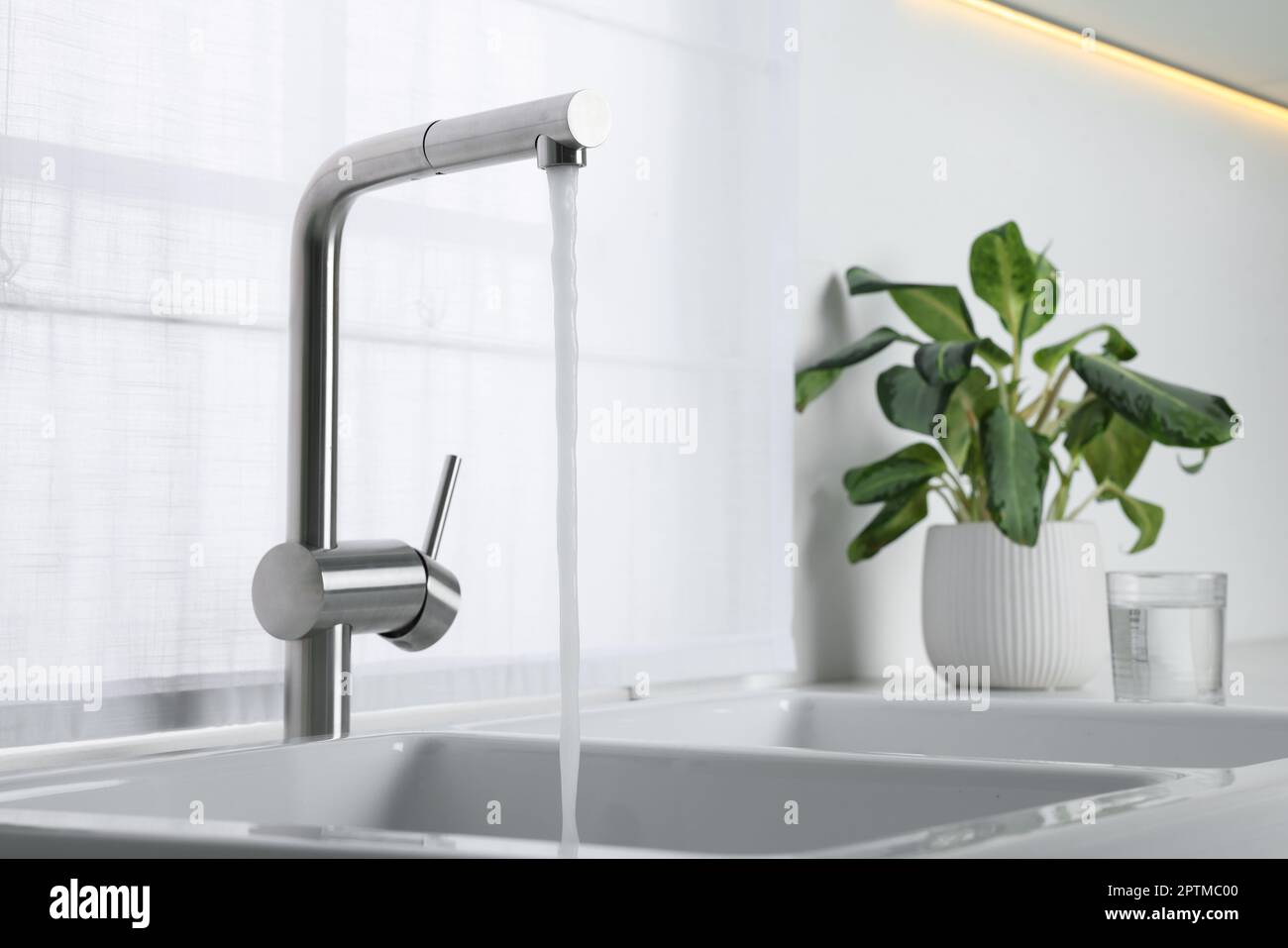 Stream of water flowing from tap in kitchen Stock Photo - Alamy