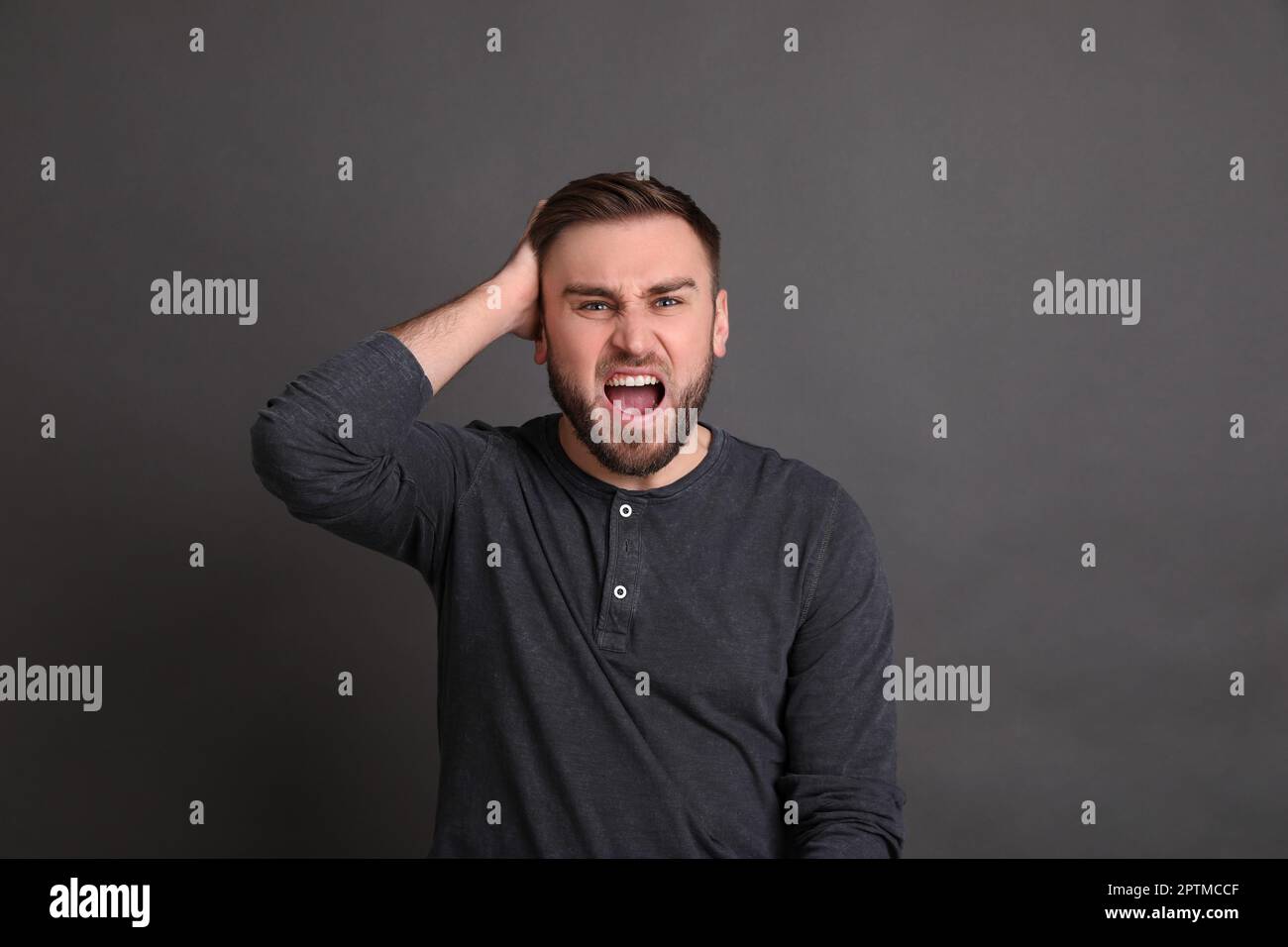 Portrait of emotional young man on grey background. Personality concept ...