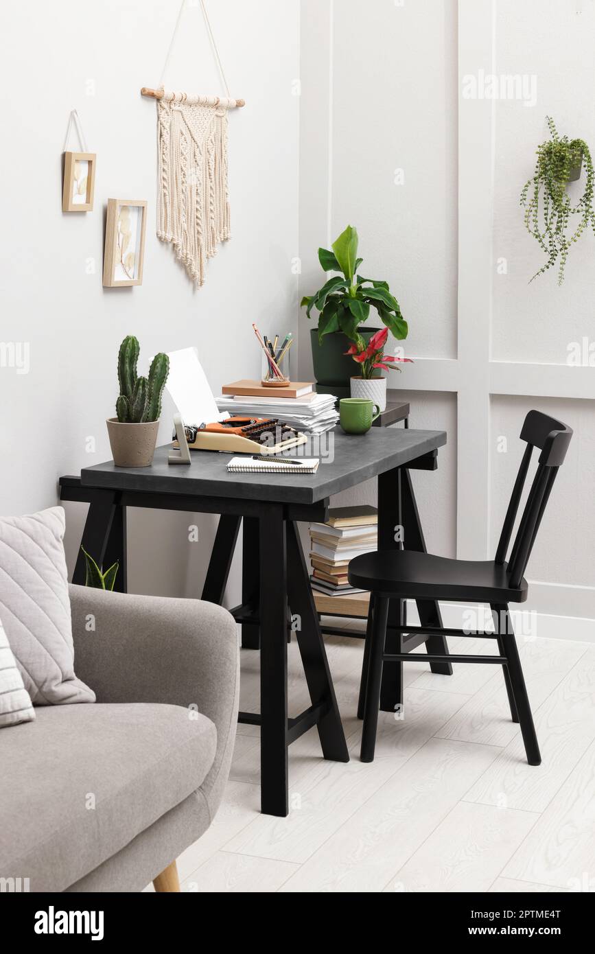 Typewriter and stack of papers on dark table in room. Writer's ...
