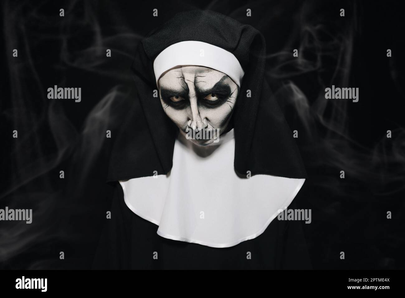Portrait of scary devilish nun on black background. Halloween party ...