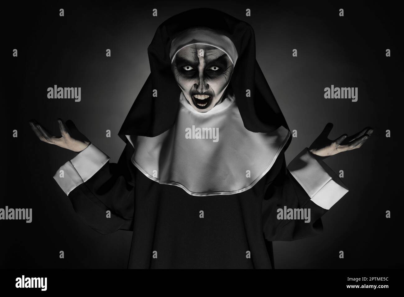 Portrait of scary devilish nun on black background. Halloween party ...