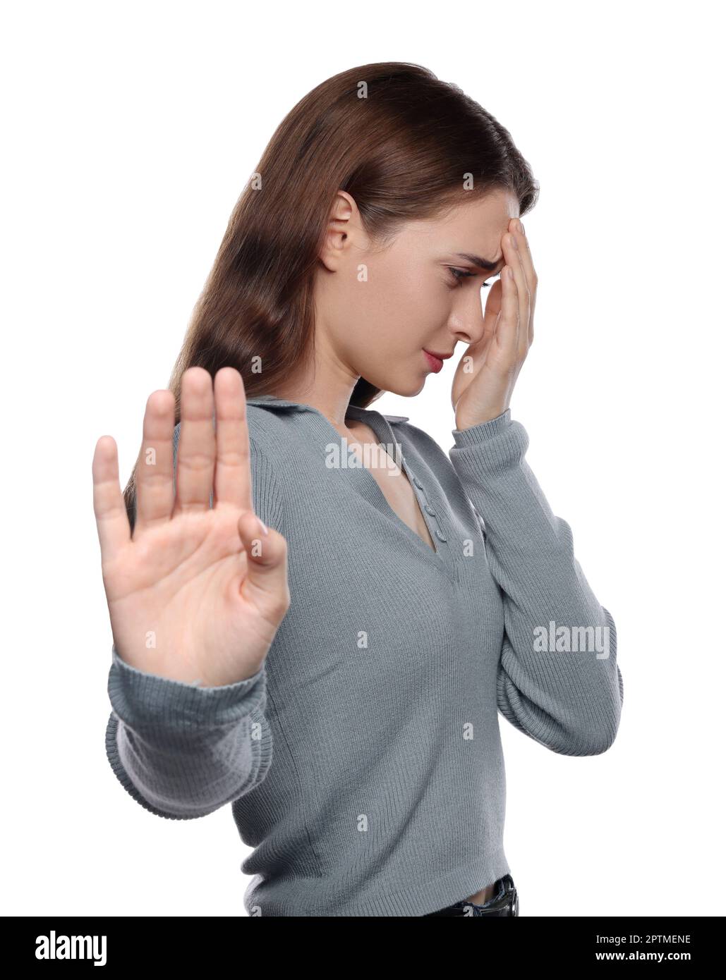 Embarrassed young woman covering face with hand on white background ...