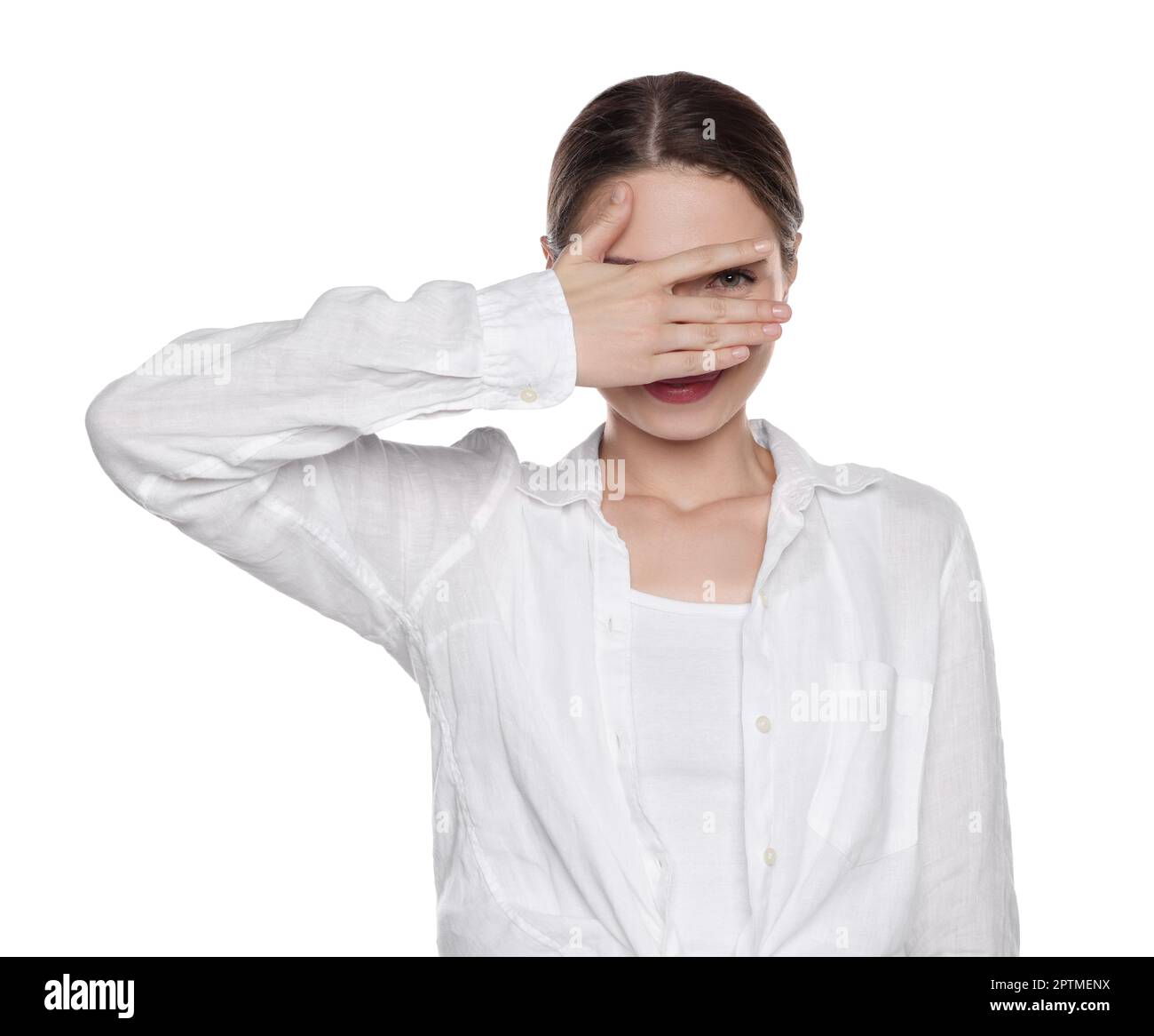Embarrassed young woman covering face with hand on white background ...