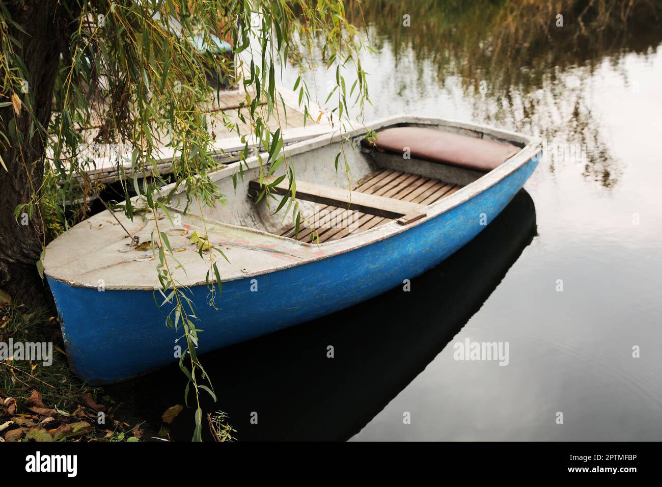 Light blue wooden boat on lake near pier Stock Photo - Alamy
