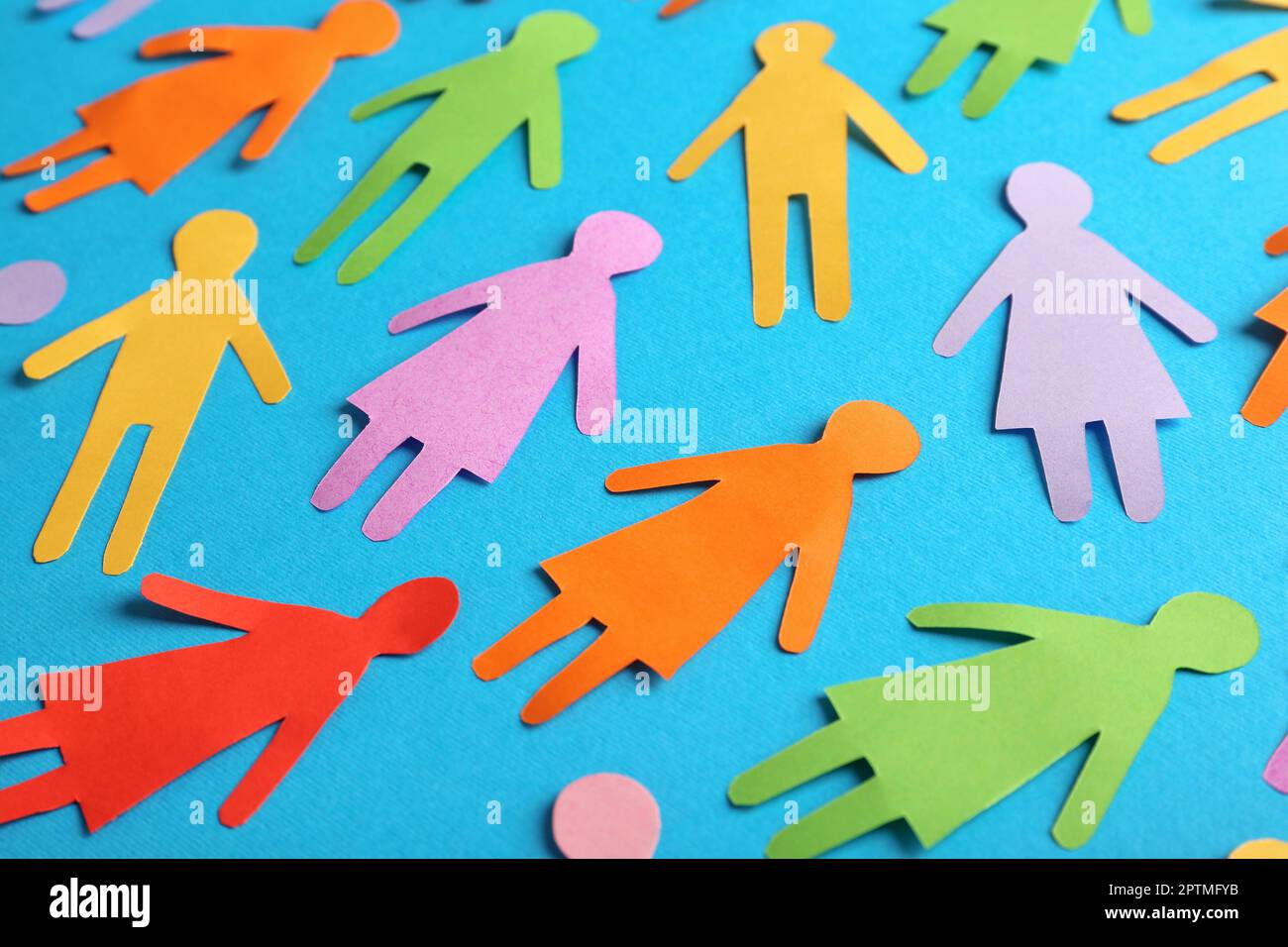 Many different paper human figures on light blue background. Diversity ...