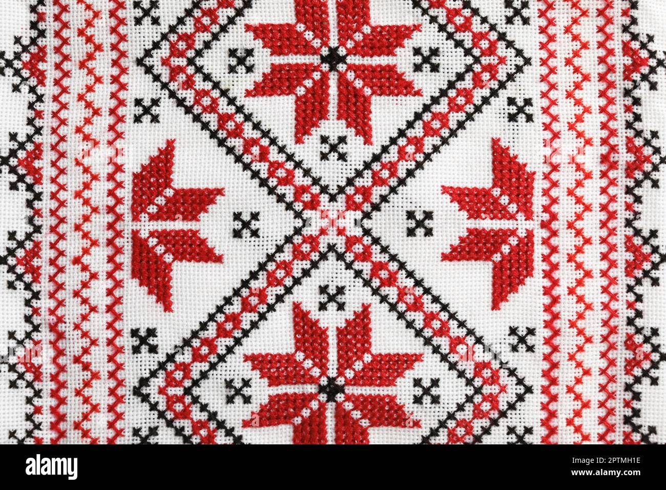 Traditional Ukrainian embroidery on white canvas as background, closeup ...