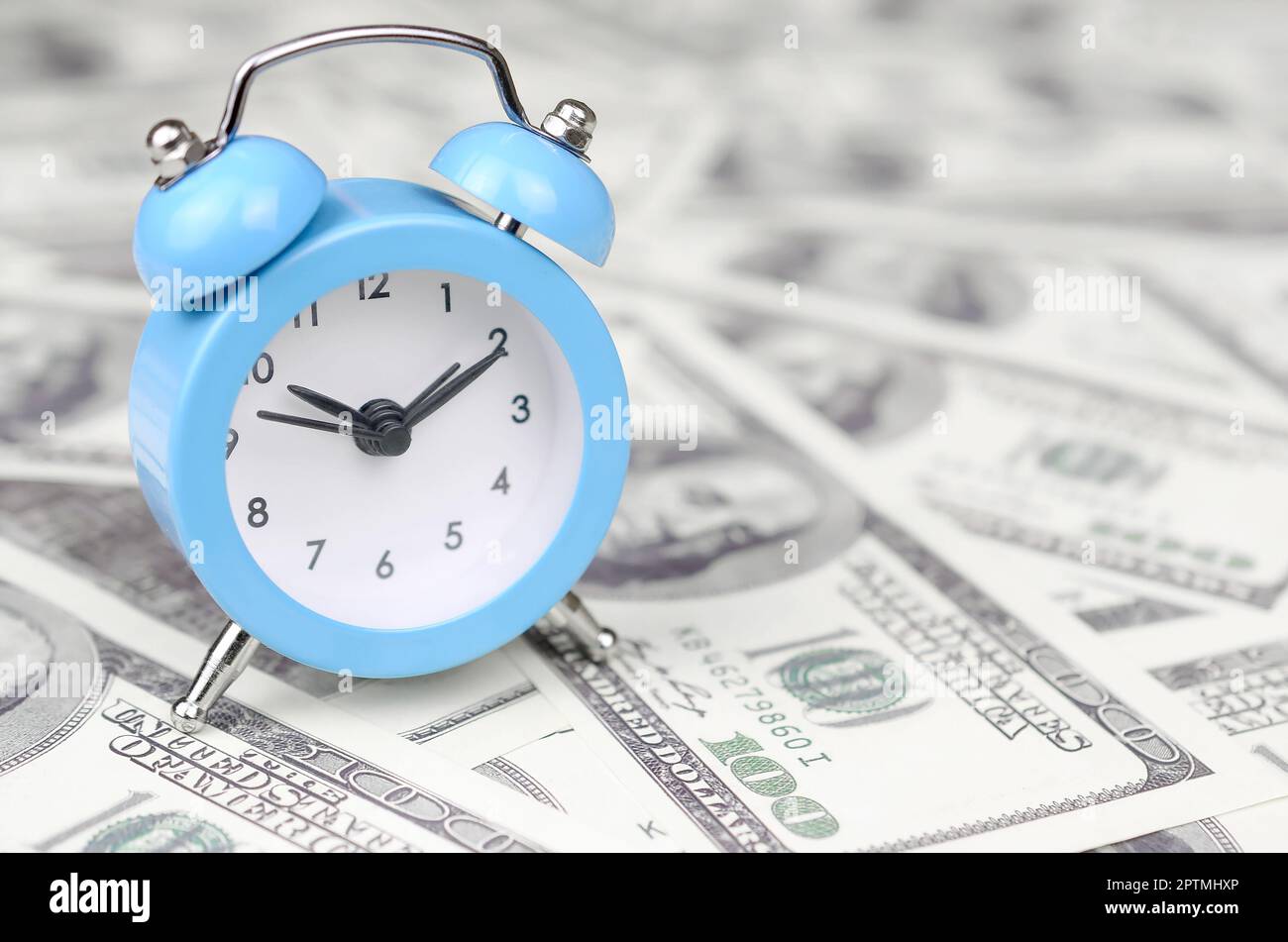 Time management concept. Blue alarm clock lies on a large amount of ...