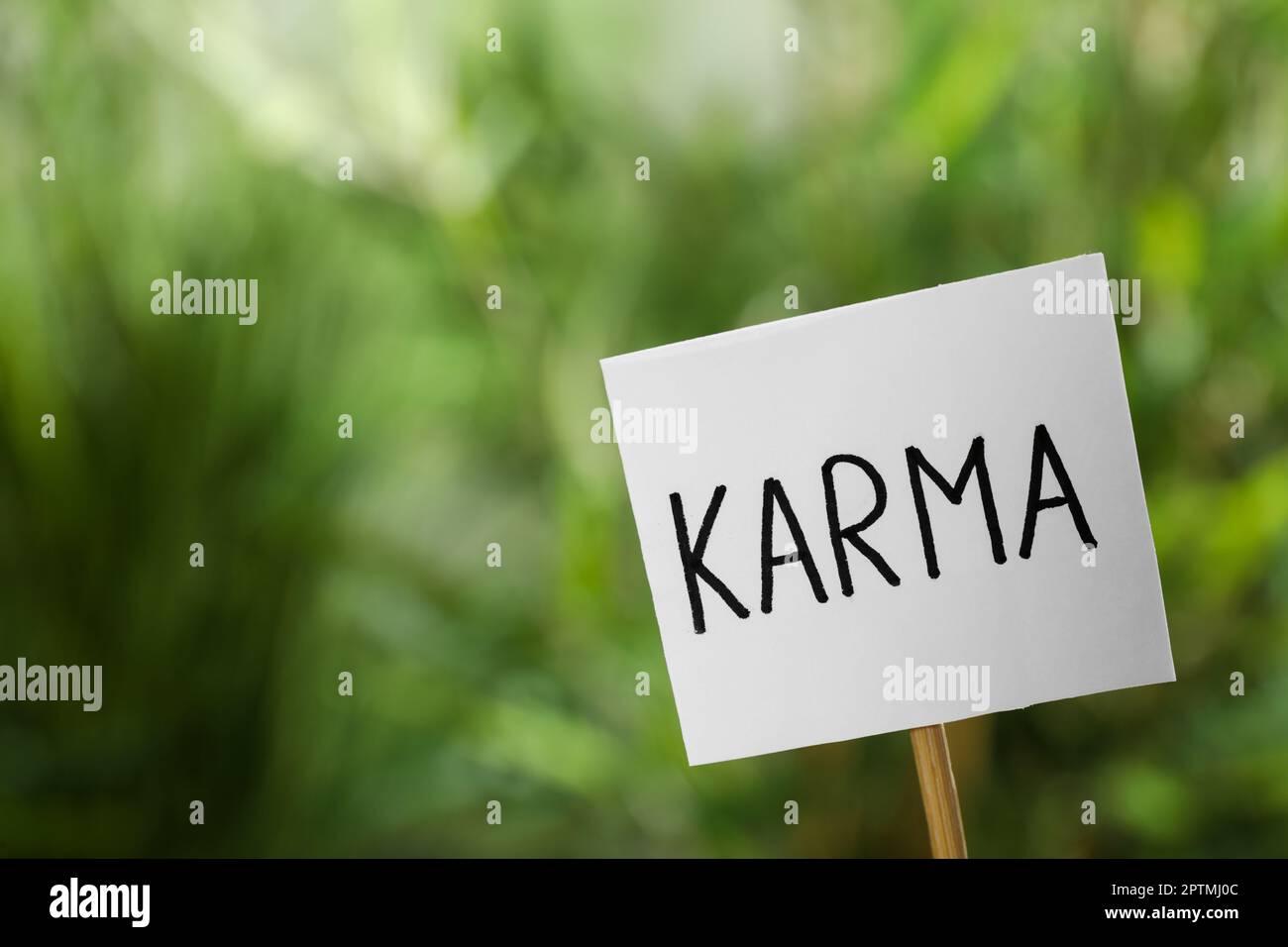 Sign with word Karma on blurred background, closeup. Space for text ...