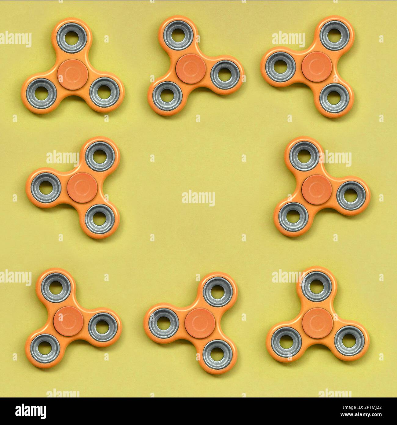 Many orange fidget spinners lies on texture background of fashion ...