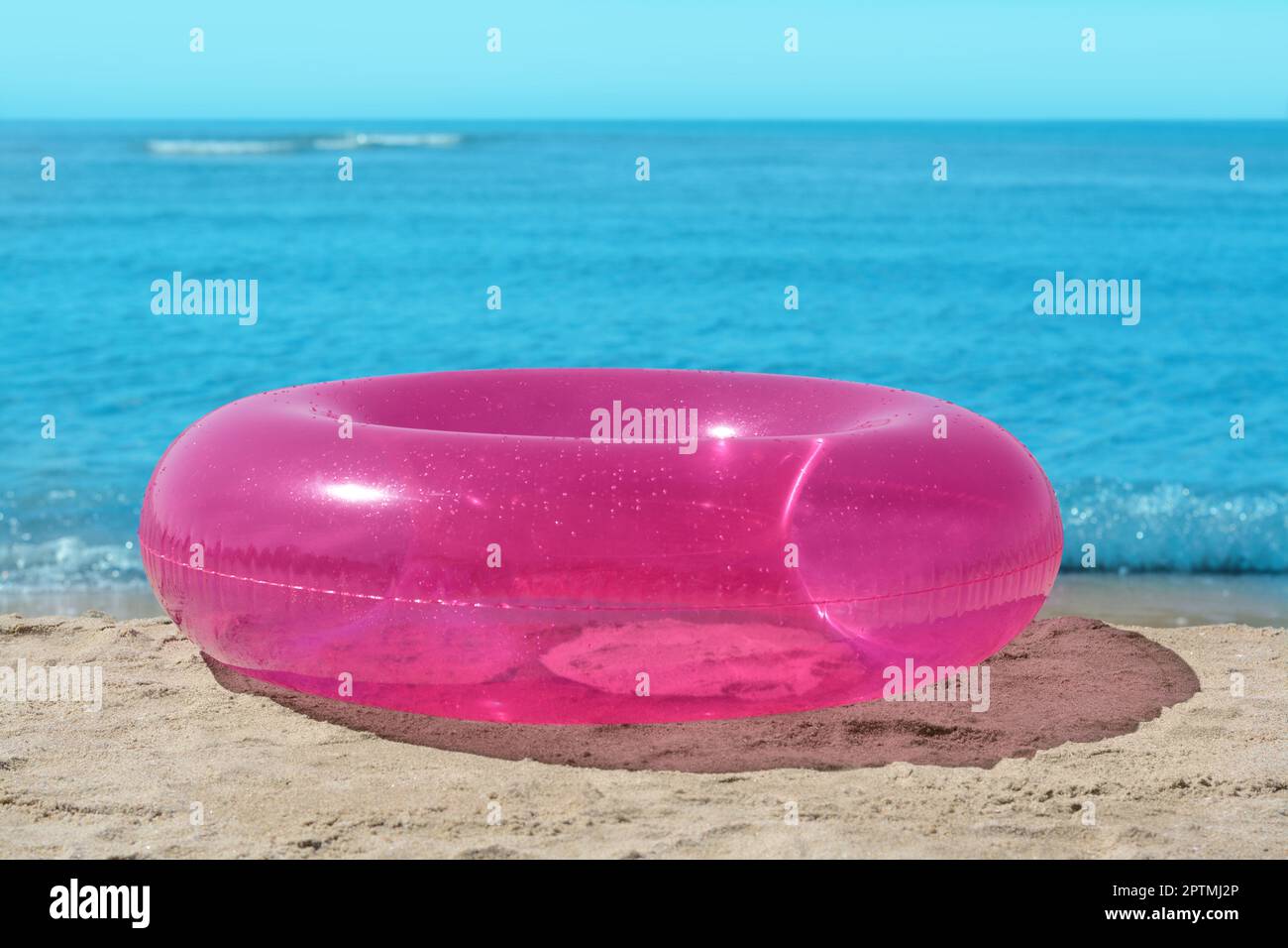 Bright inflatable ring on sandy beach near sea Stock Photo - Alamy