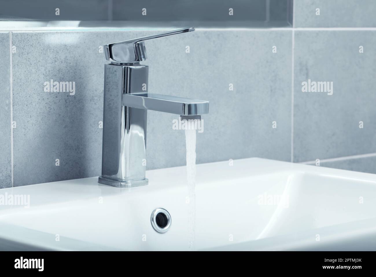 Stream of water flowing from tap in bathroom Stock Photo - Alamy