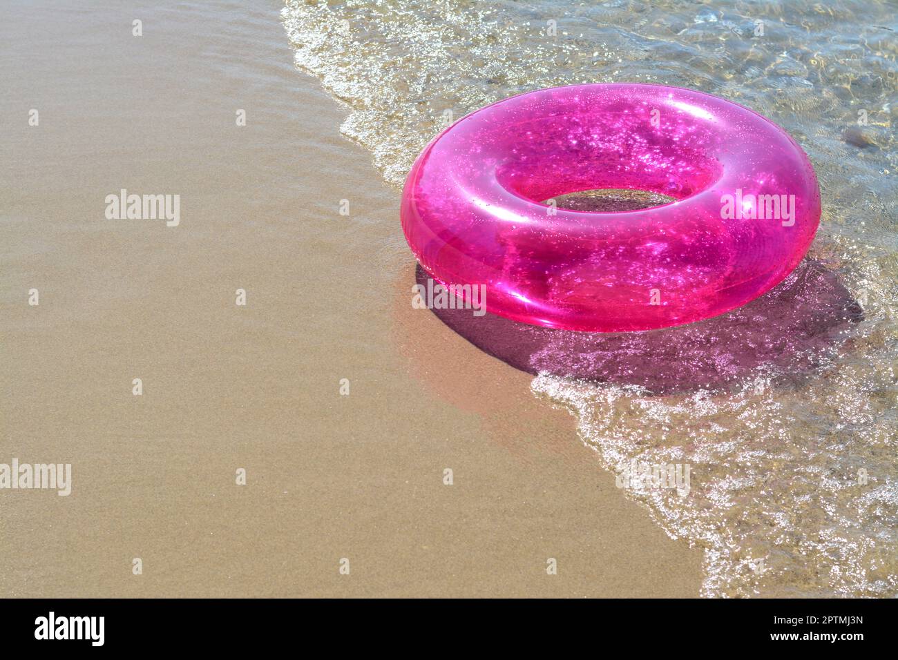 Bright inflatable ring on sandy beach near sea. Space for text Stock ...