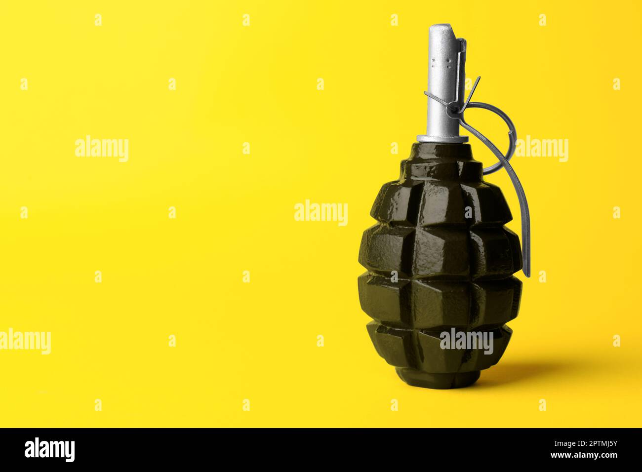 Hand grenade on yellow background. Space for text Stock Photo - Alamy