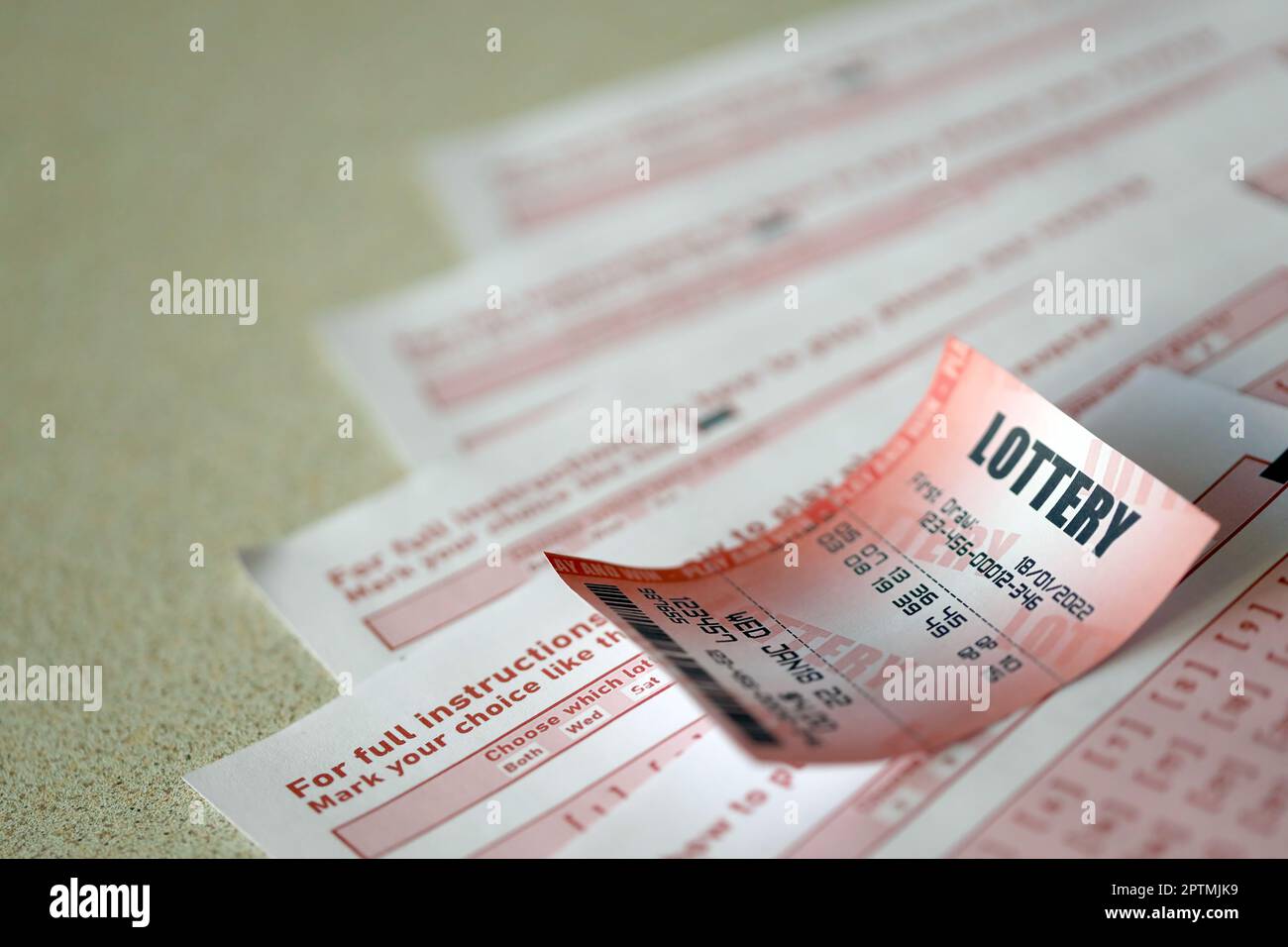 Red lottery ticket lies on pink gambling sheets with numbers for ...
