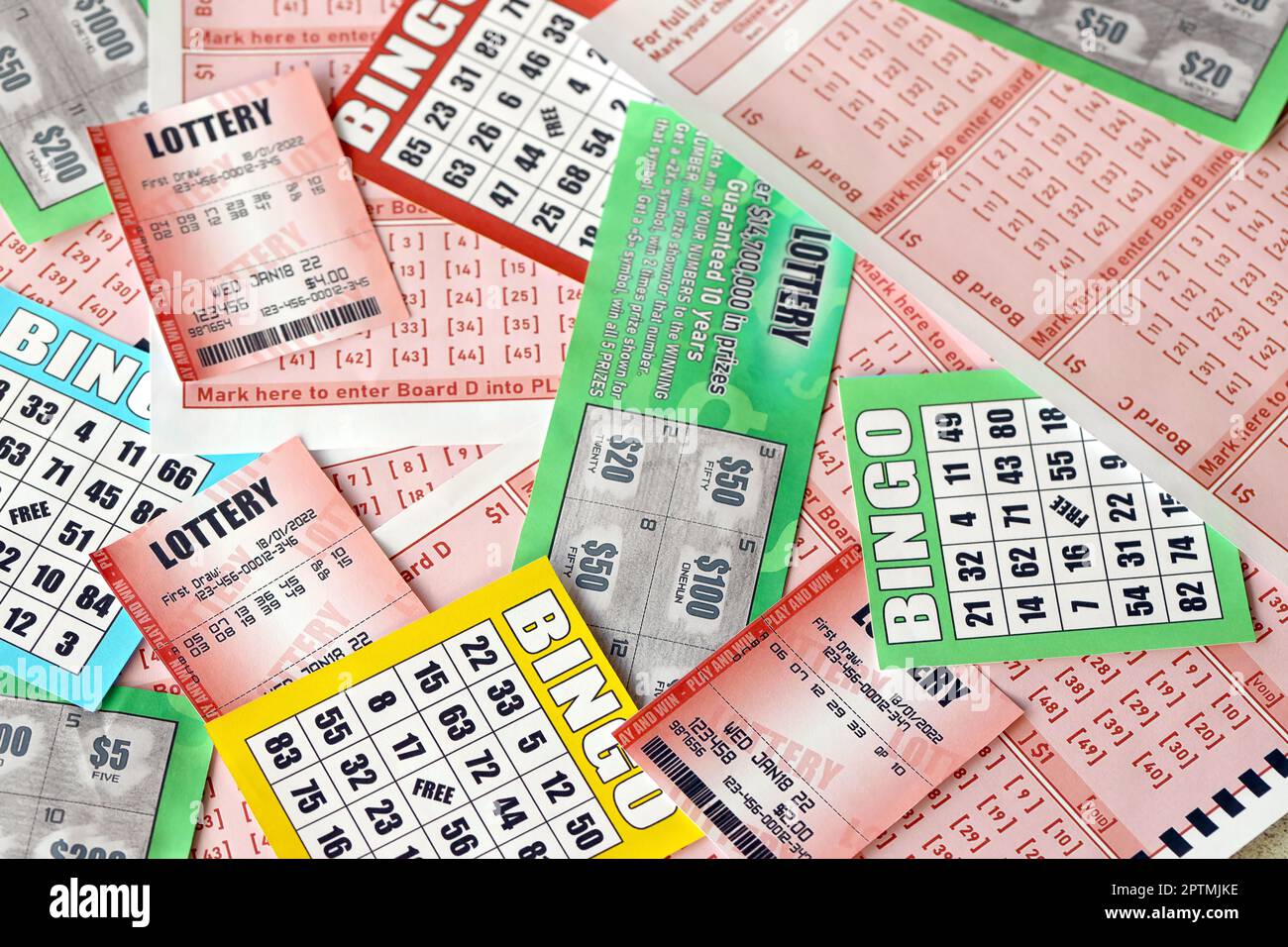 Many used lottery tickets, bills with numbers and bingo playing boards ...