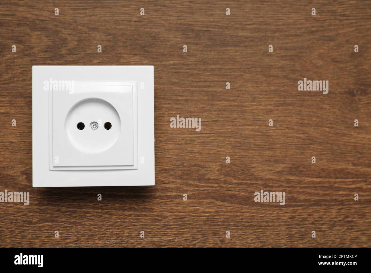 Modern plastic power socket on wooden table, top view. Space for text ...