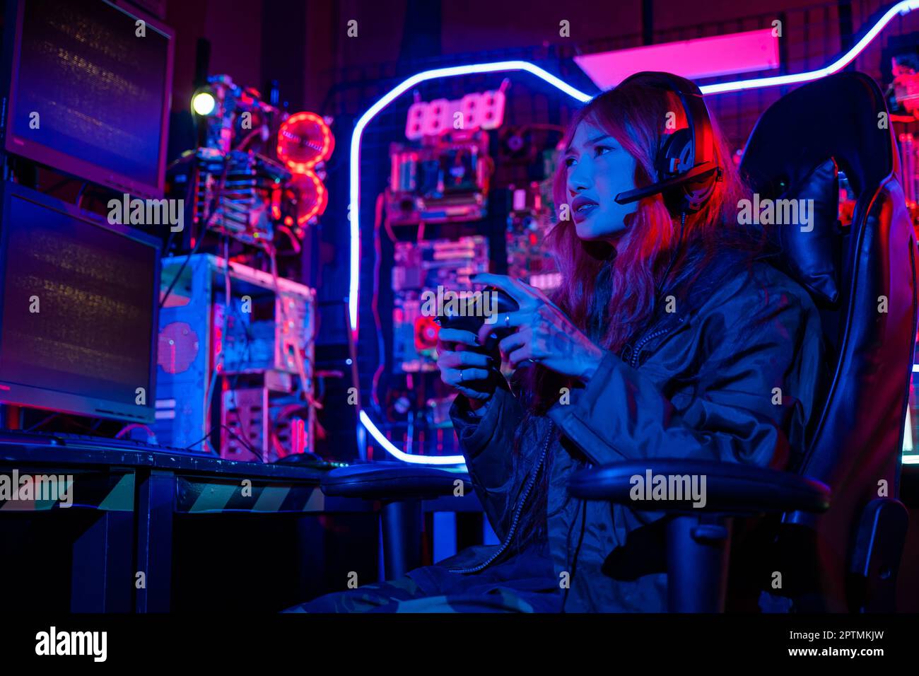 Young woman wear gaming headphones playing esports games console gaming ...