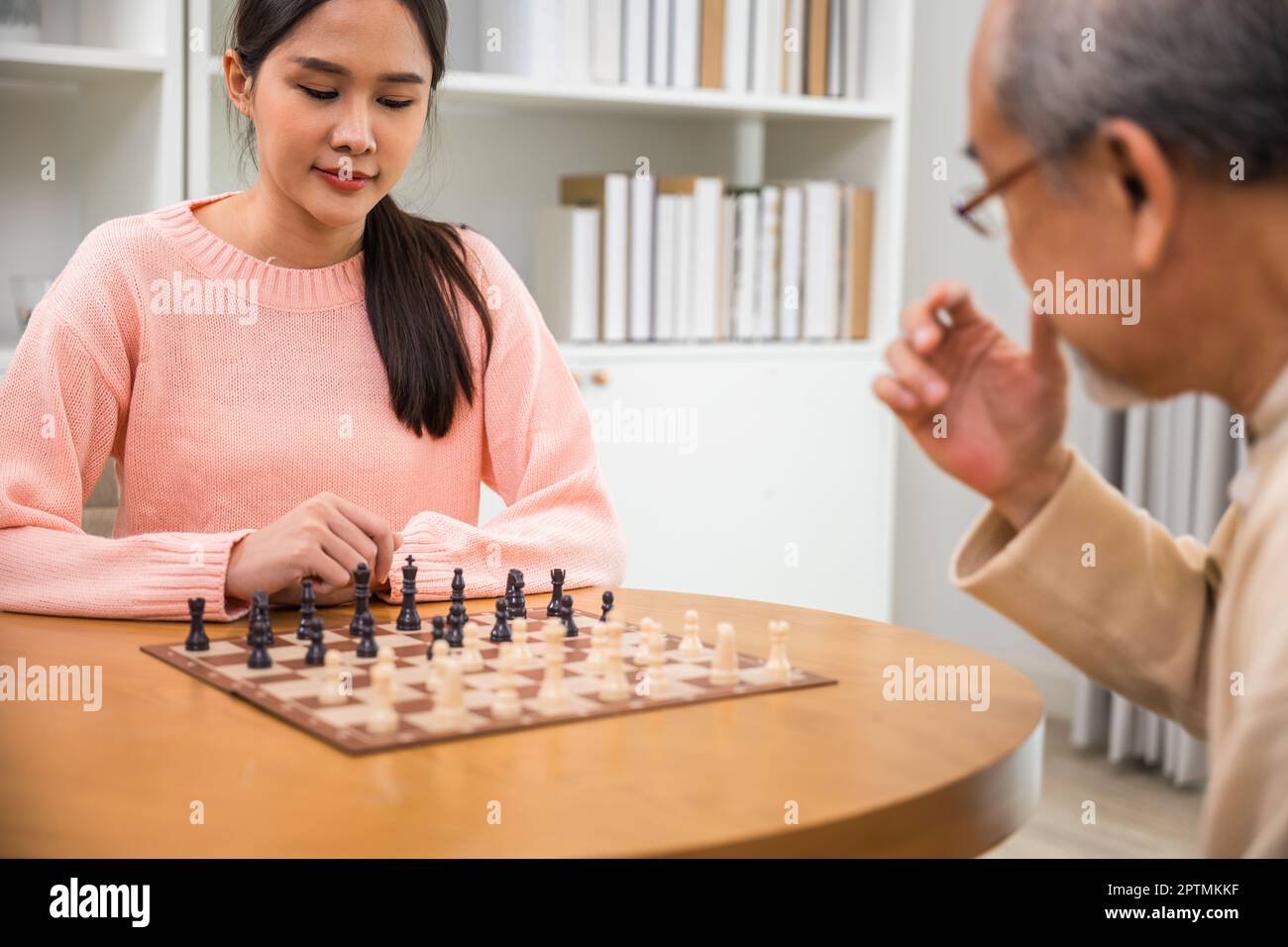 Beautiful young smile woman having fun sitting playing chess game with ...