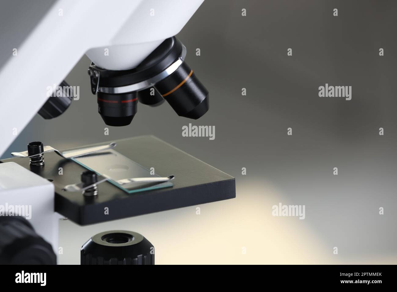 Modern medical microscope with glass slide on blurred background ...