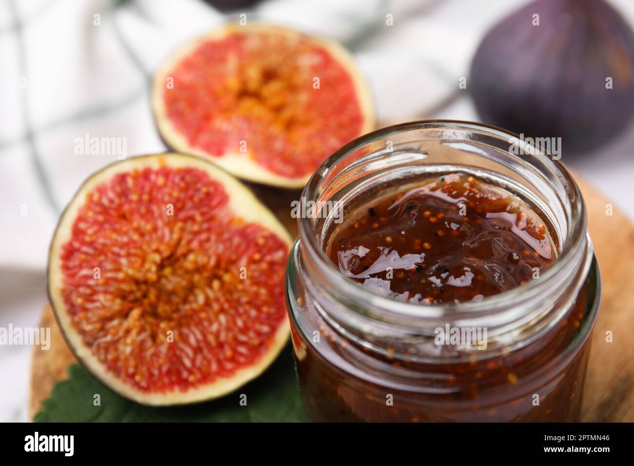 Tasty sweet fig jam in jar and fruits on table, closeup Stock Photo - Alamy