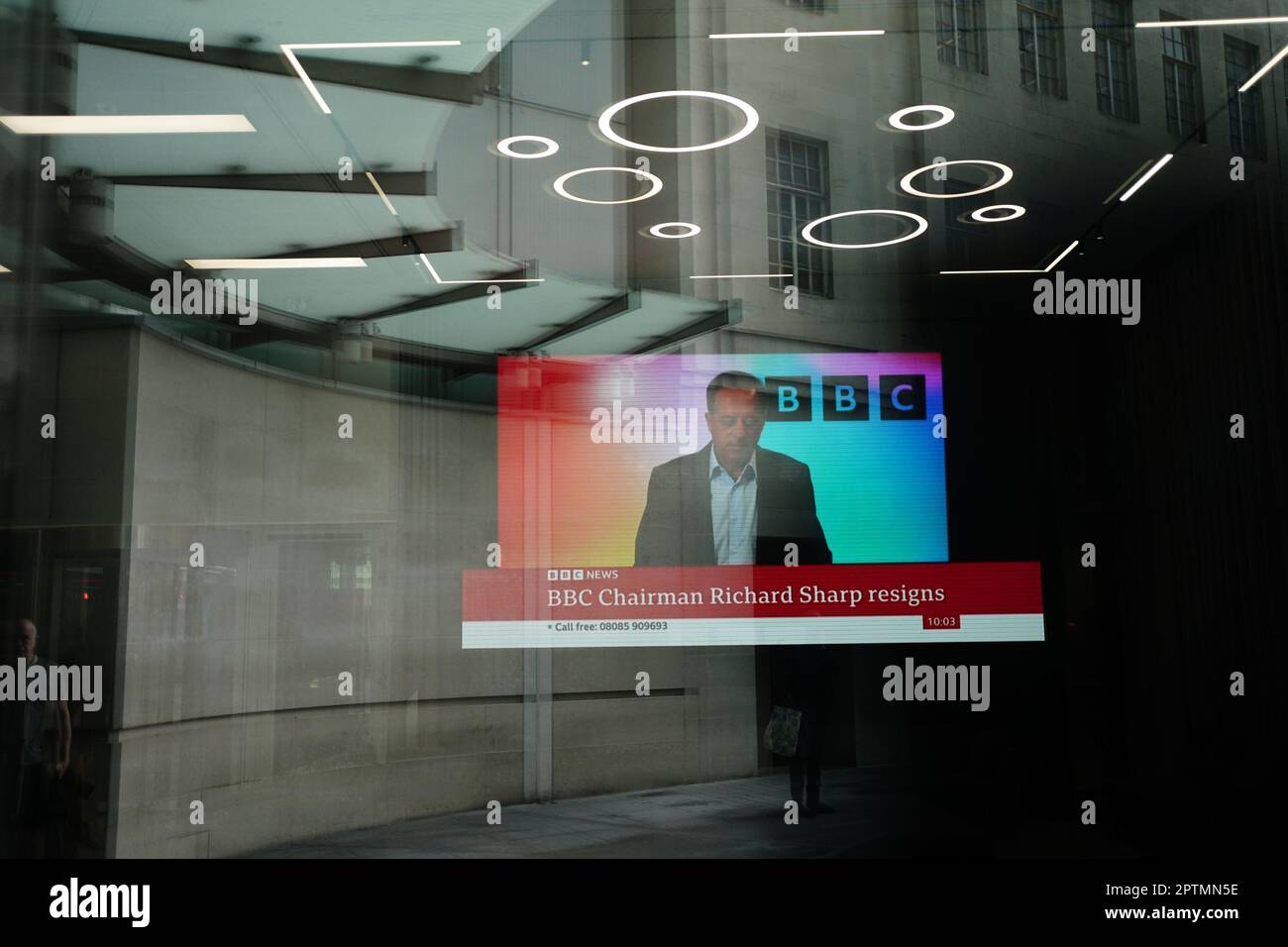 A screen showing a news report seen through the windows of the BBC in ...
