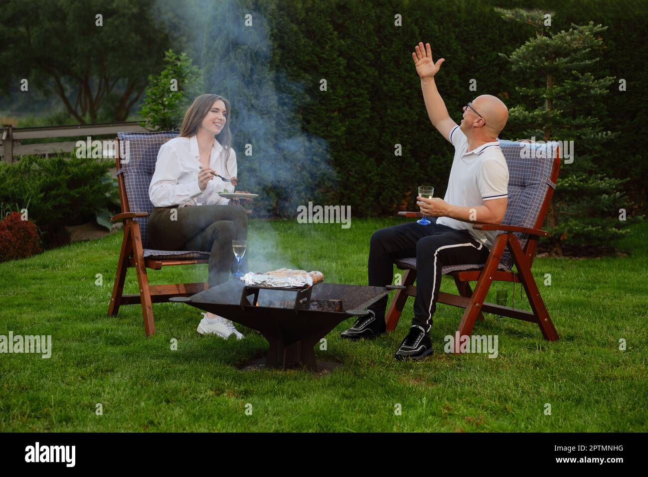 Happy family having late evening barbecue picnic outdoors Stock Photo ...