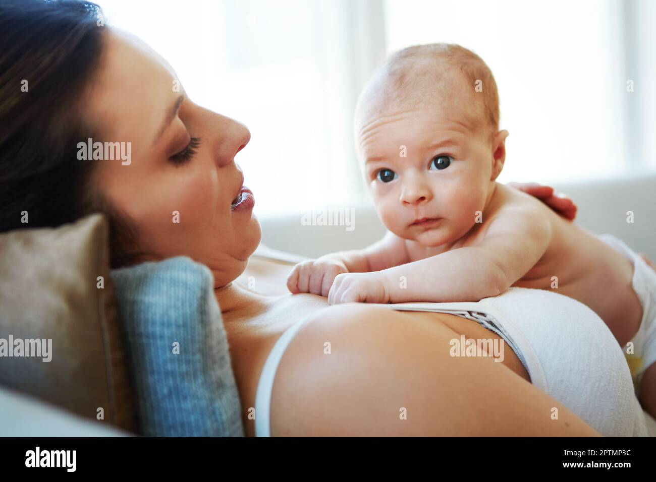 Hes so special to me. a mother lying down with her newborn baby on top of her Stock Photo - Alamy