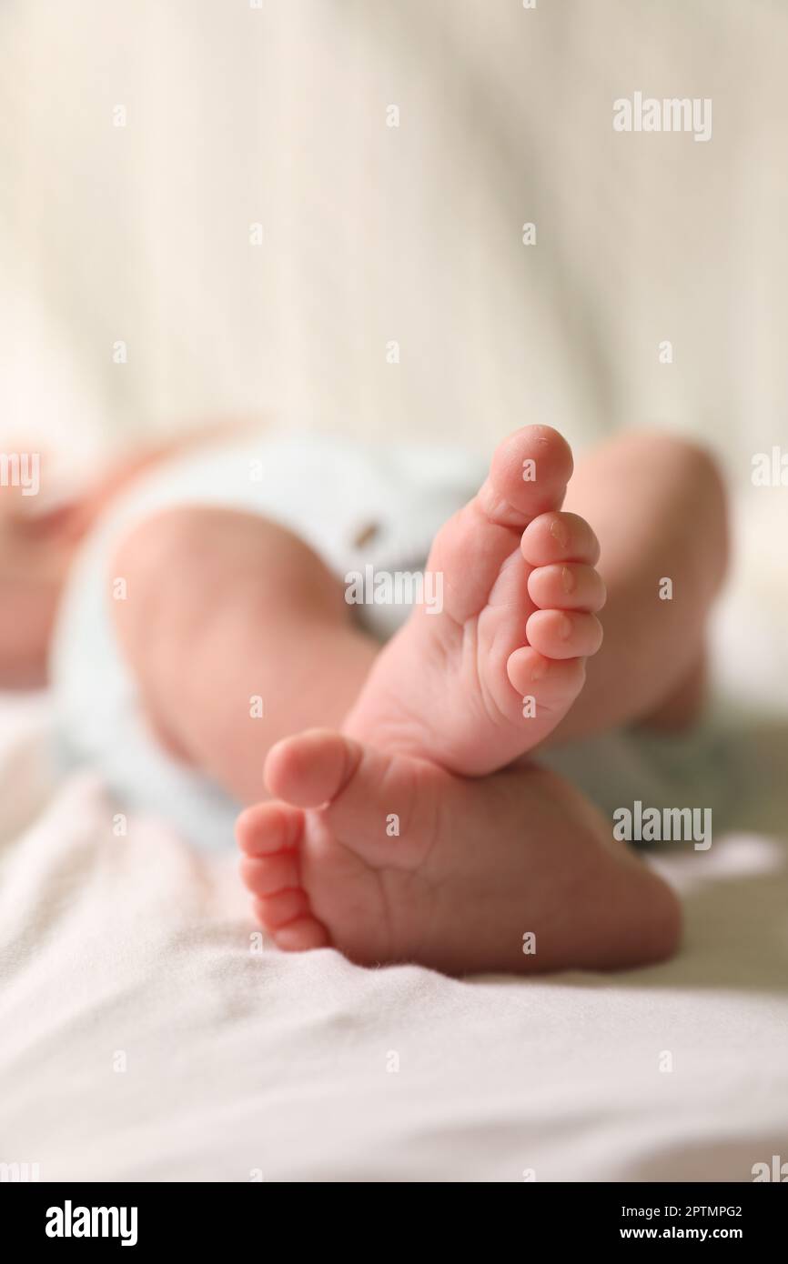 Cute newborn baby lying on bed, closeup of legs Stock Photo - Alamy