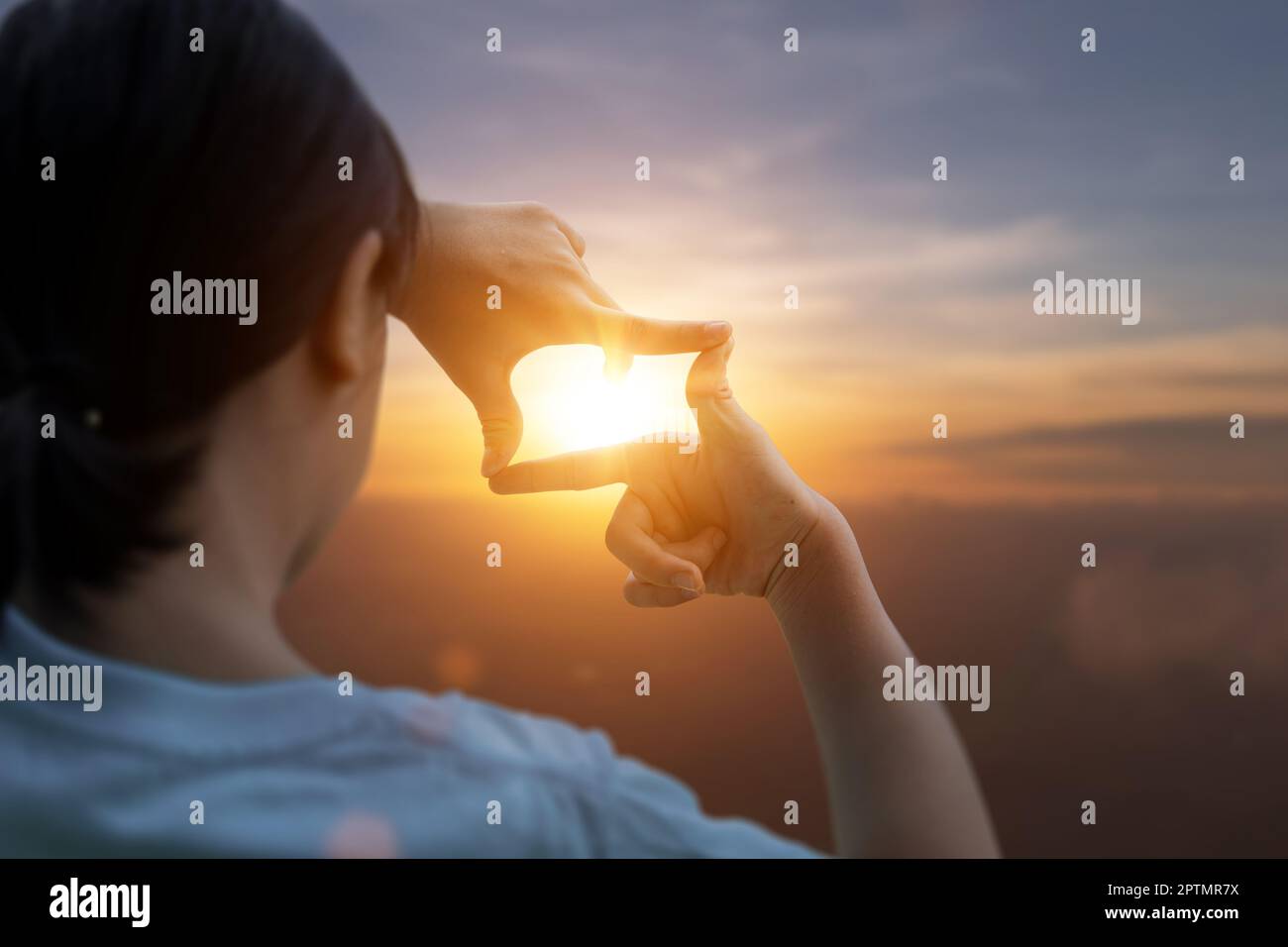 Child girl making frame around the sun with her hands capturing in the ...