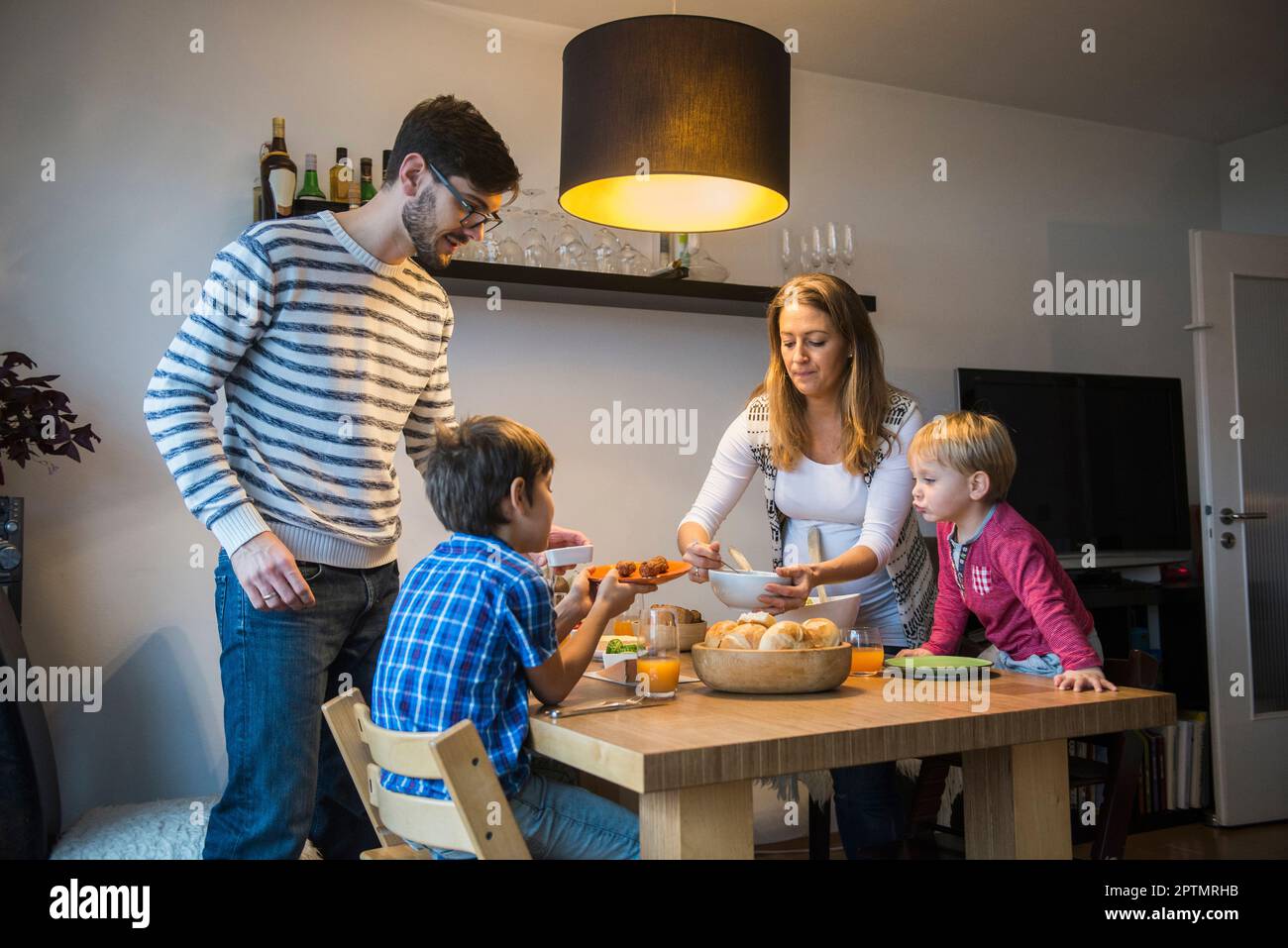 Mother serving food to her family, Munich, Germany Stock Photo - Alamy