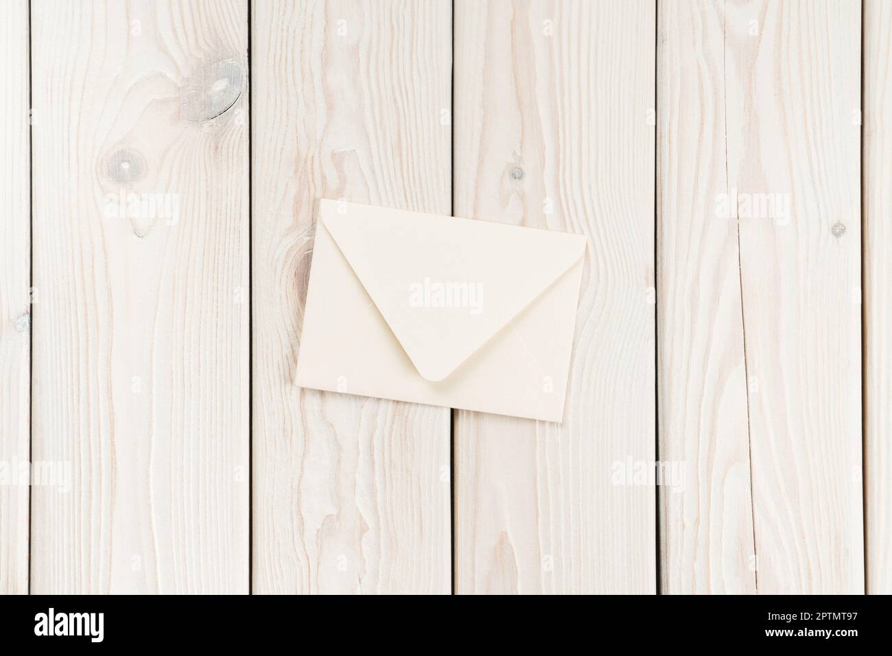 White craft handmade closed paper envelope laying on white wooden plank ...