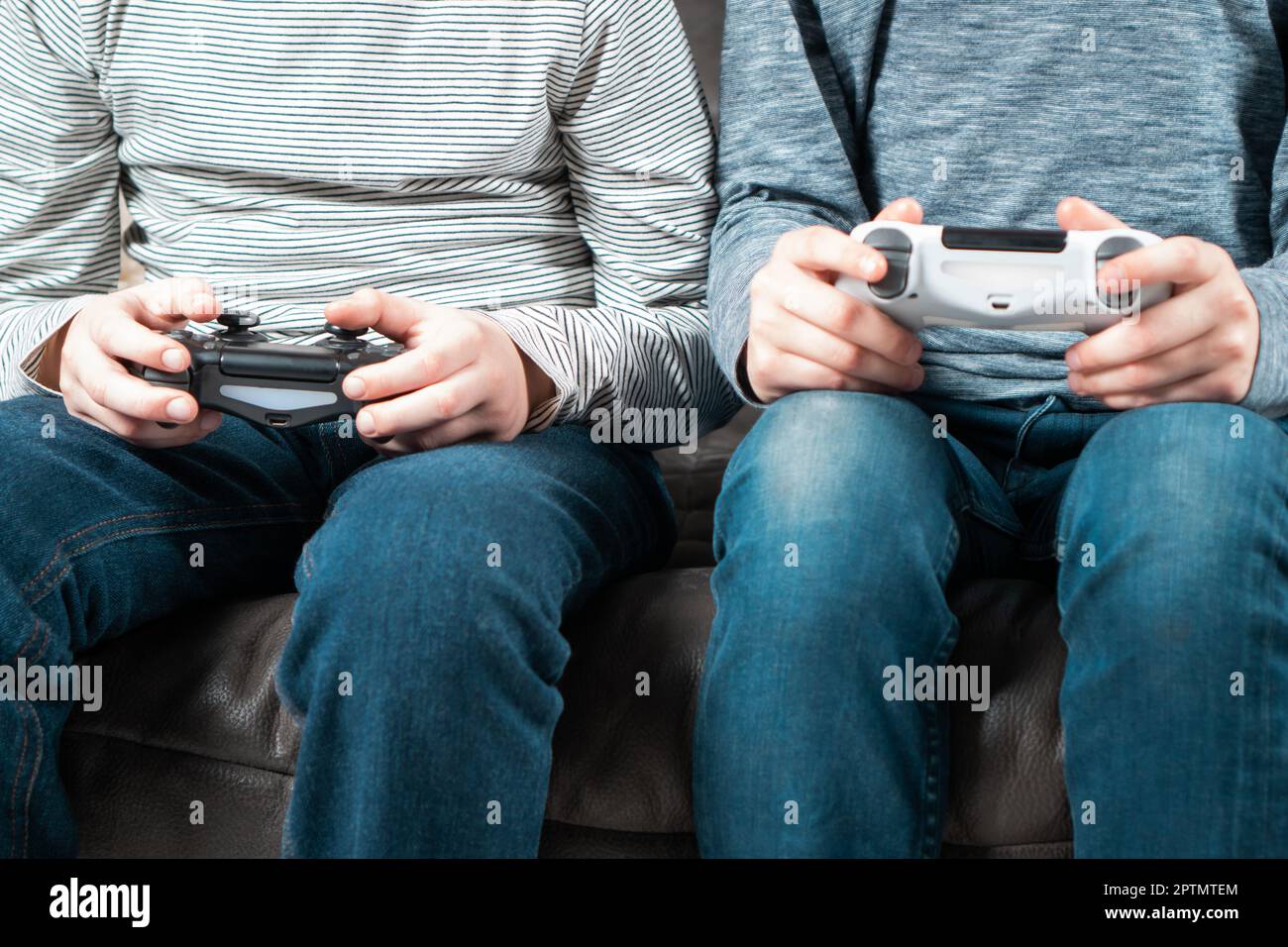 Male hands hold modified plastic joysticks. Friends play videogames ...