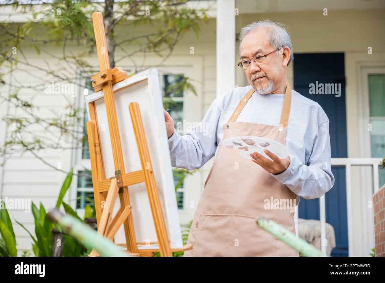 Lifestyle elderly people smile paint at his easel outside home, Asian ...