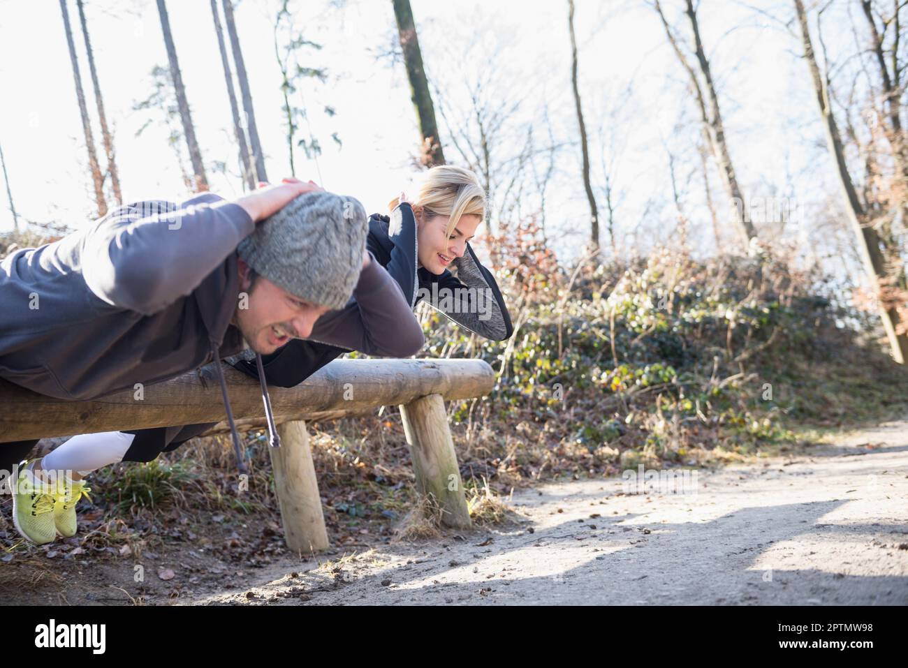 Couple doing abdominal exercise on fitness trail in nature Stock Photo ...