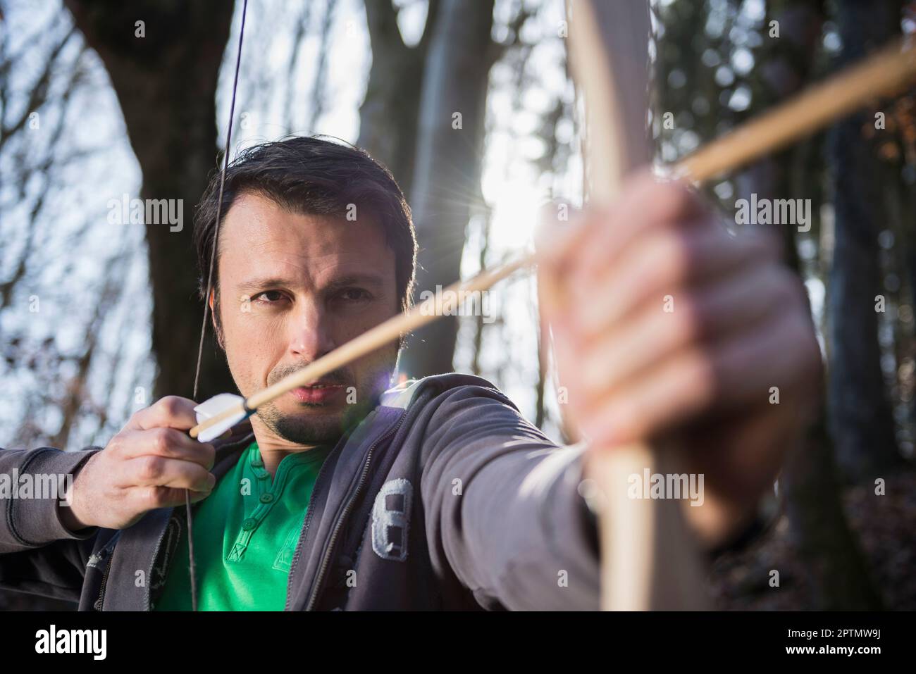 Mature man shooting with bow and arrow Stock Photo - Alamy