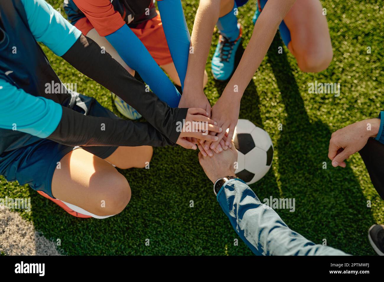 Football coach motivating junior football team before match stacking ...