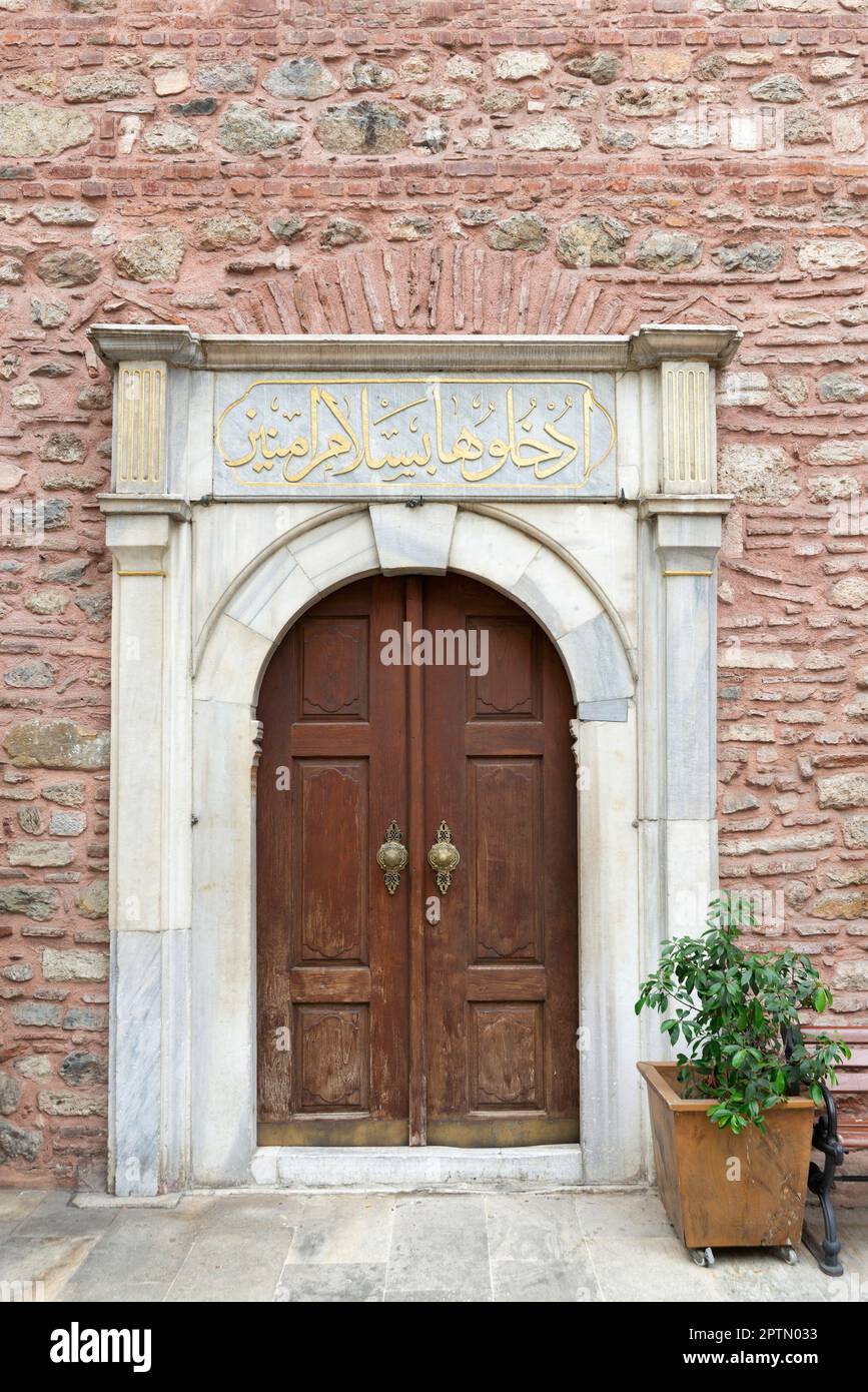 White marble decorated entrance of Arap Mosque, with wooden arched door ...